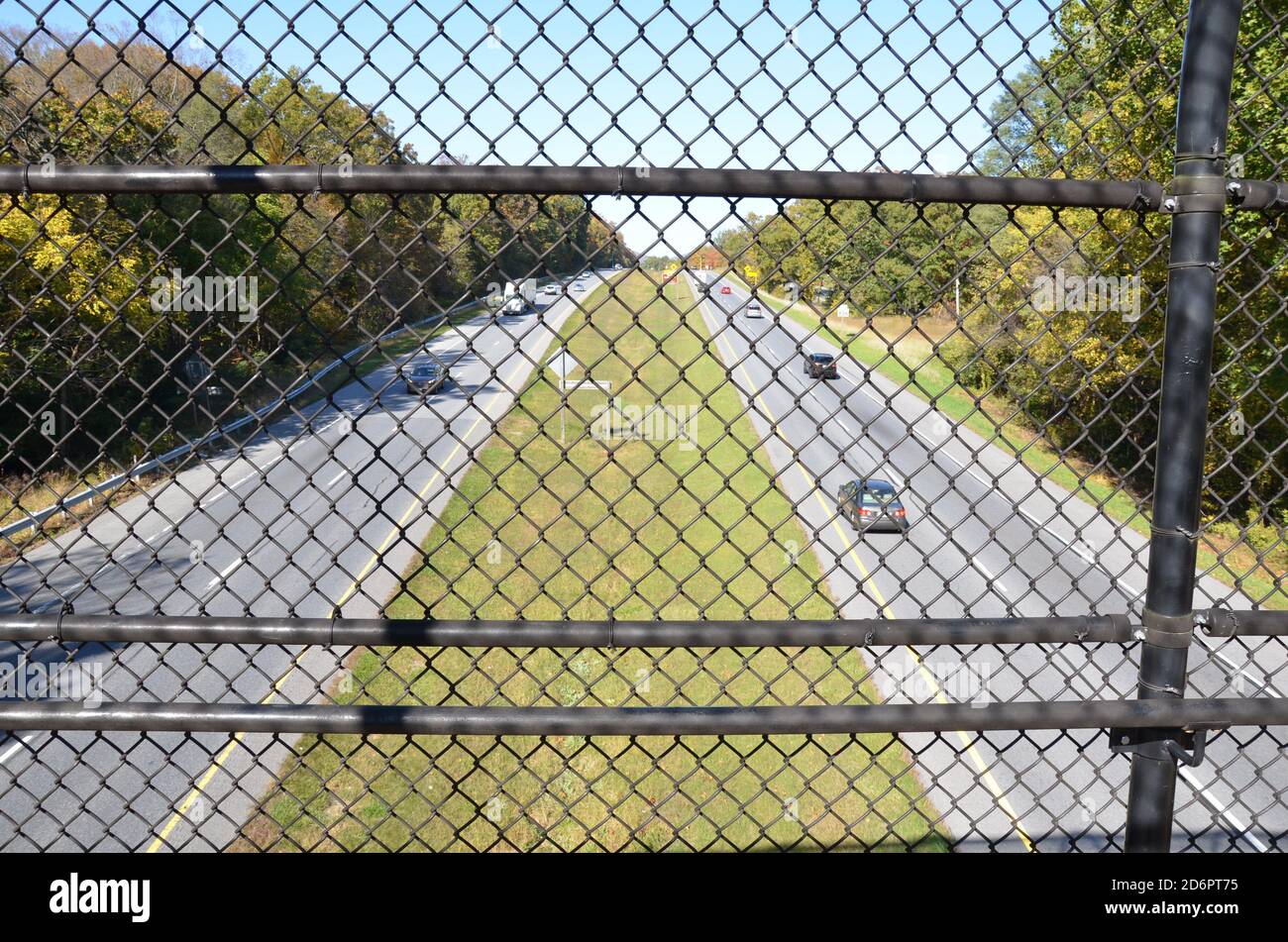 metal chain link fence over highway or road with cars Stock Photo - Alamy