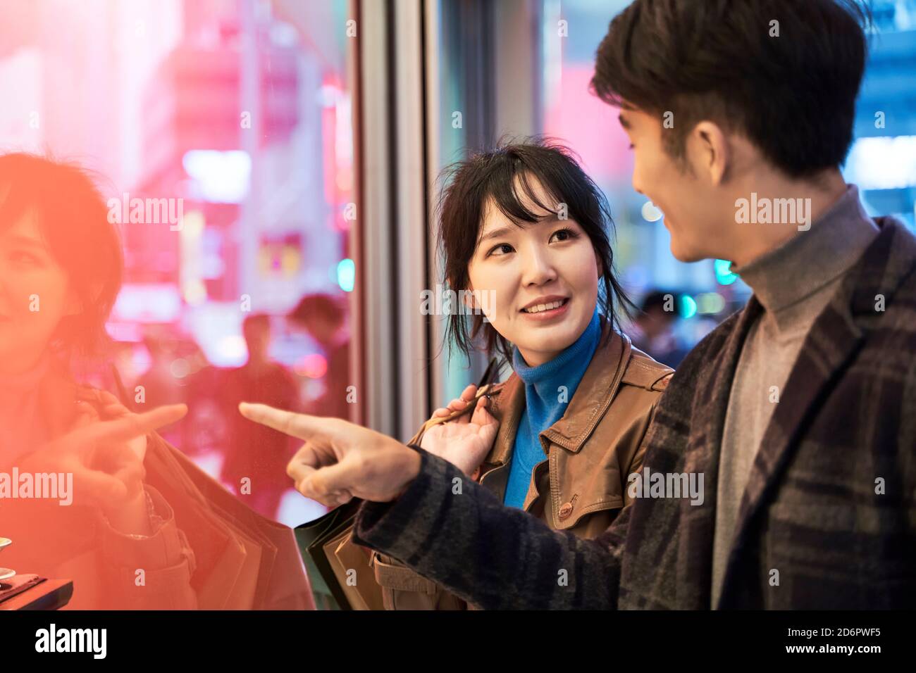 loving young asian couple looking at shop window and talking happy and ...
