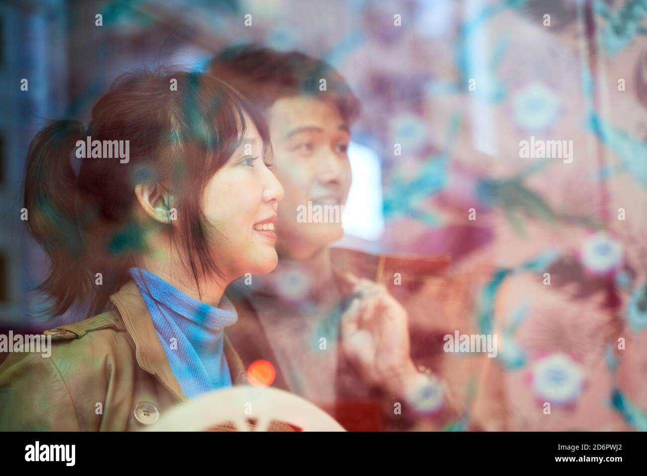 happy young asian couple looking into shop window in modern city Stock ...