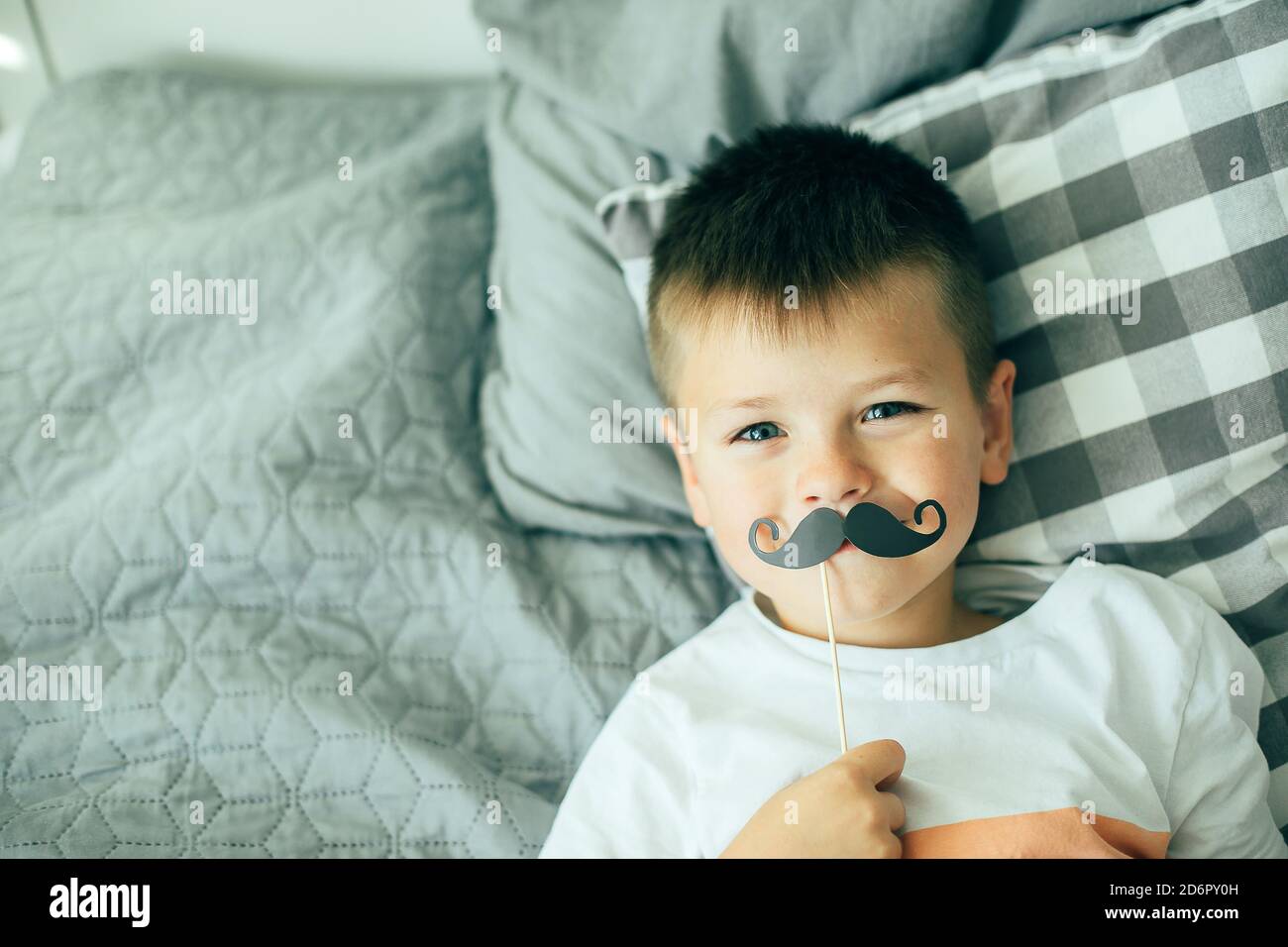 Portrait of funny kid with fake mustache. Happy child playing in home ...