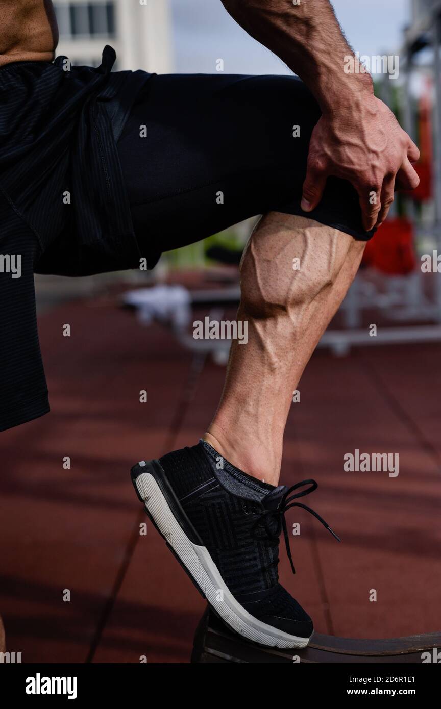 strong young athlete with mighty calves muscle wearing sneakers on ...
