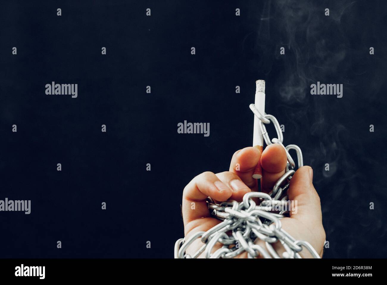 Male hand in metal chains holding cigarette Stock Photo - Alamy