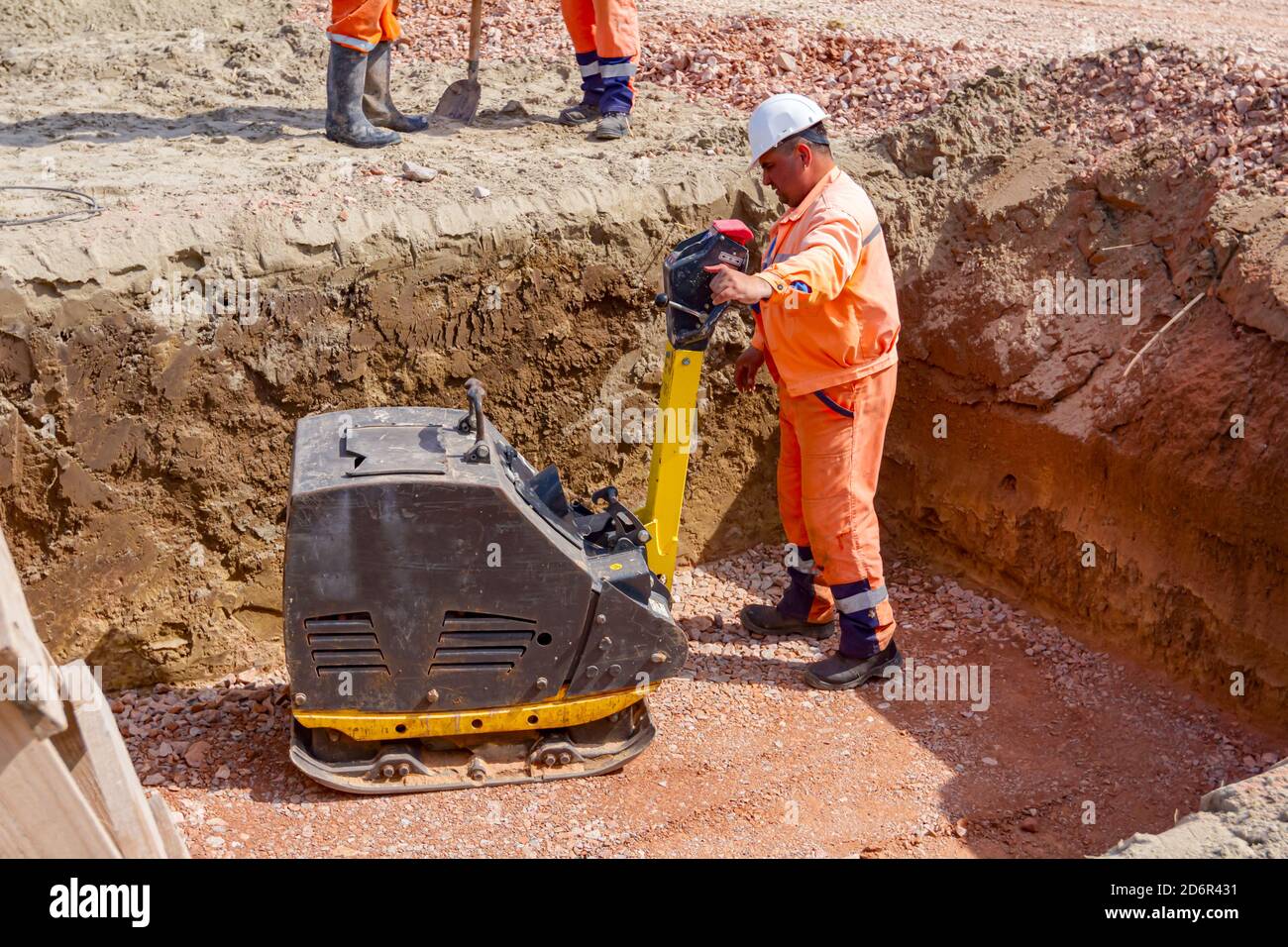 Worker is compacting gravel with vibration plate compactor machine in ...