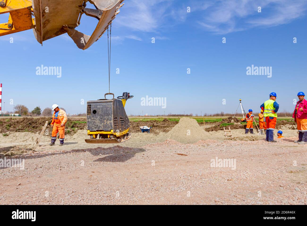 Excavator is carry, over building site with raised up front bucket ...