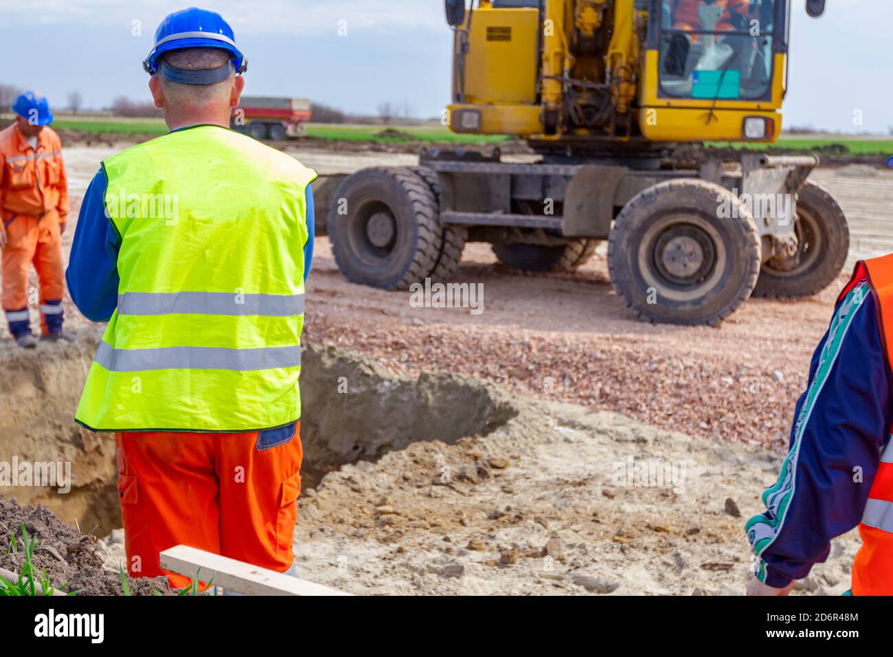 View from behind on construction worker, foreman, with safety blue ...