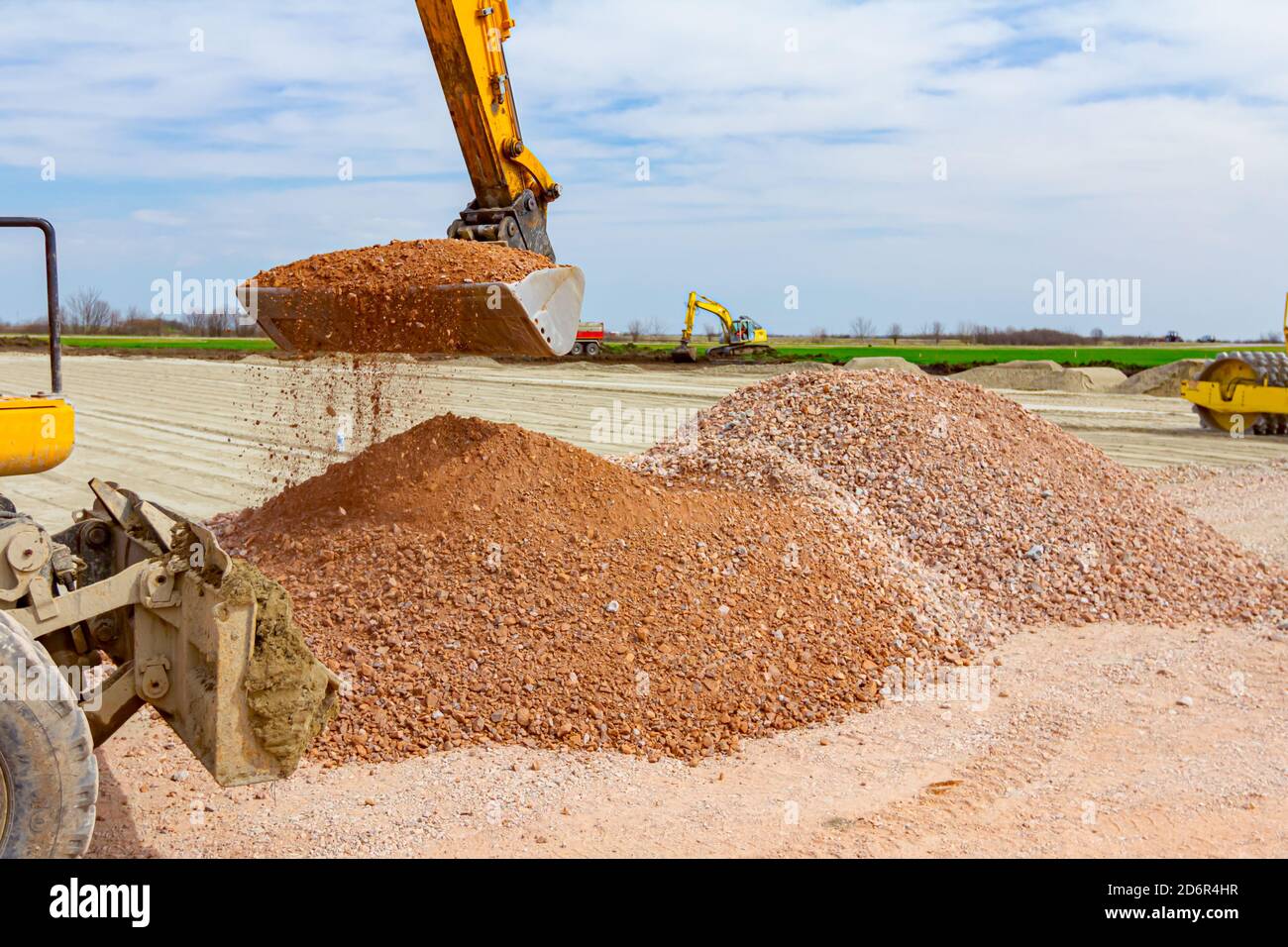 Excavator is catching fraction, small crushed stone, with his front ...