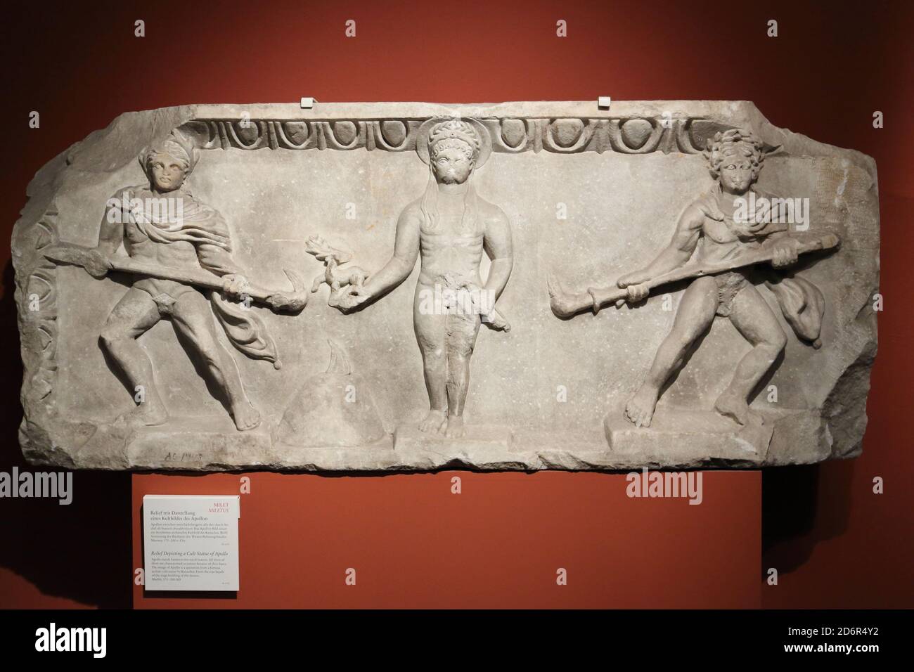 Relief depicting a cult statue of Apollo standing between two torch ...