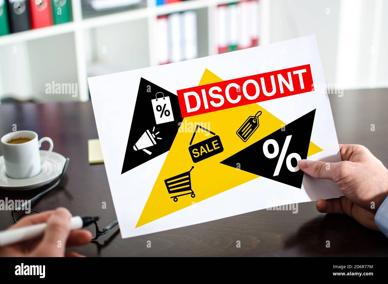 Hand holding a paper showing discount concept Stock Photo - Alamy