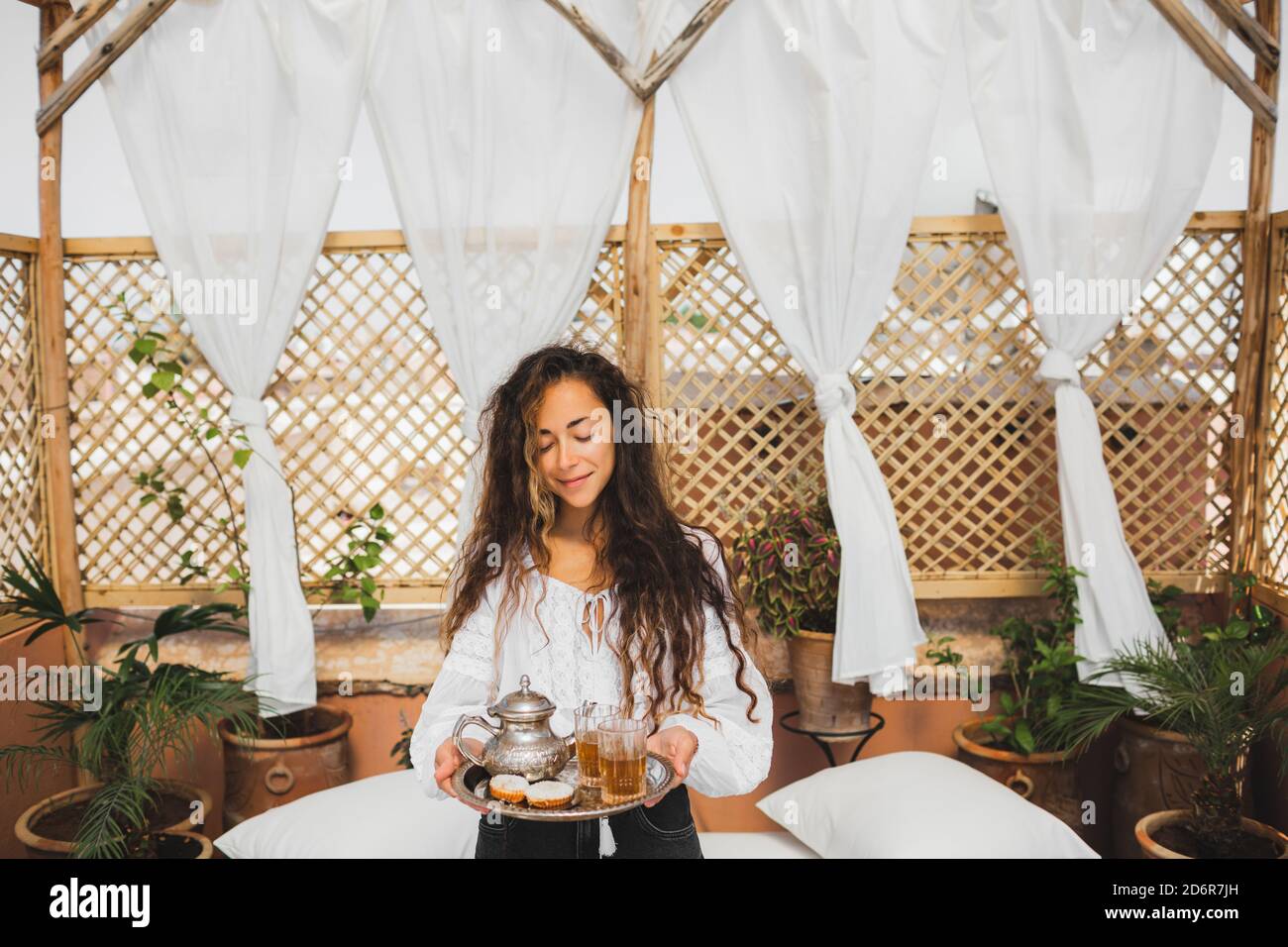 Beautiful young oriental woman holding tray with traditional moroccan ...