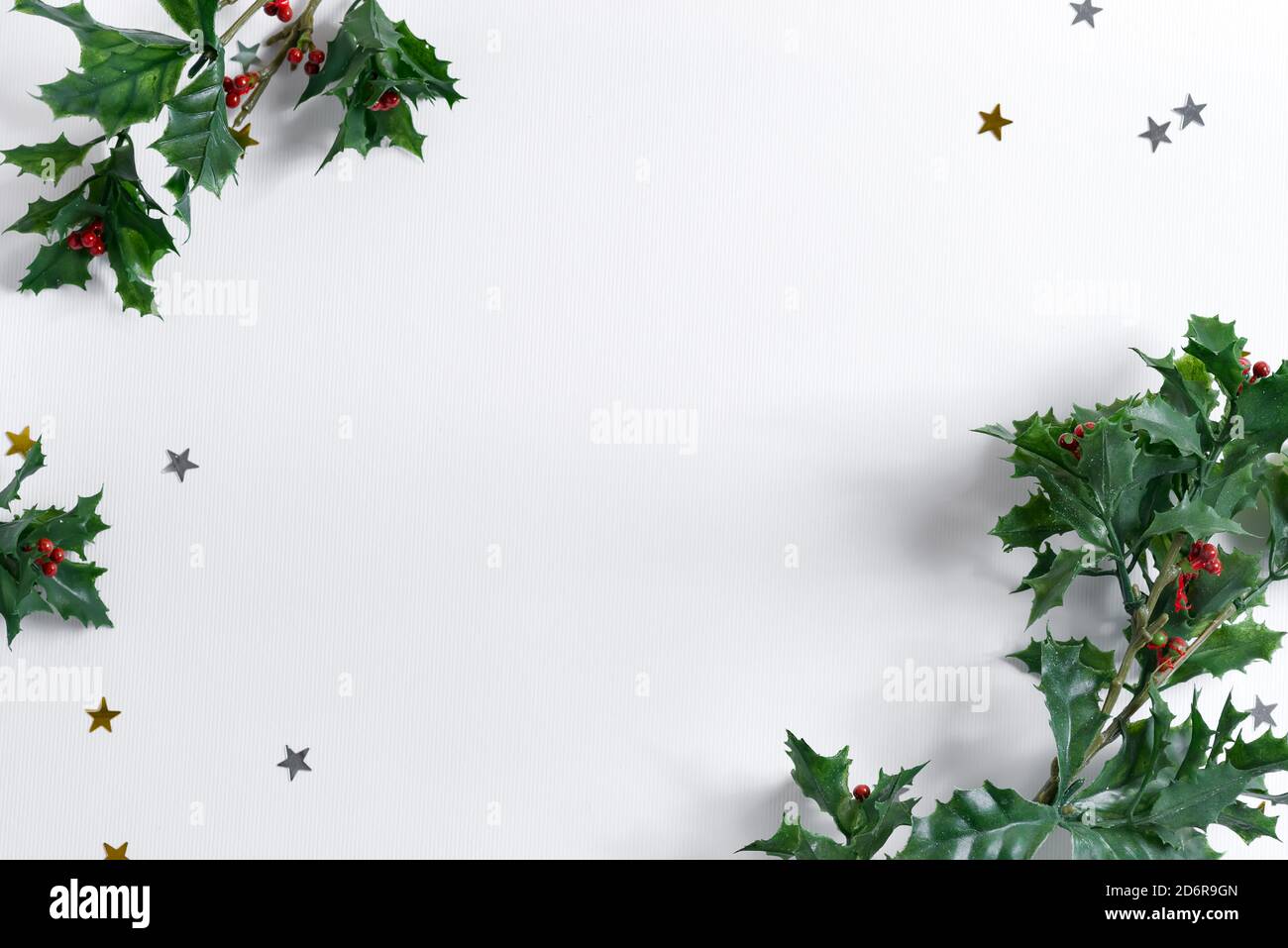 Festive Christmas corner frame decorated green holly leaves and stars ...