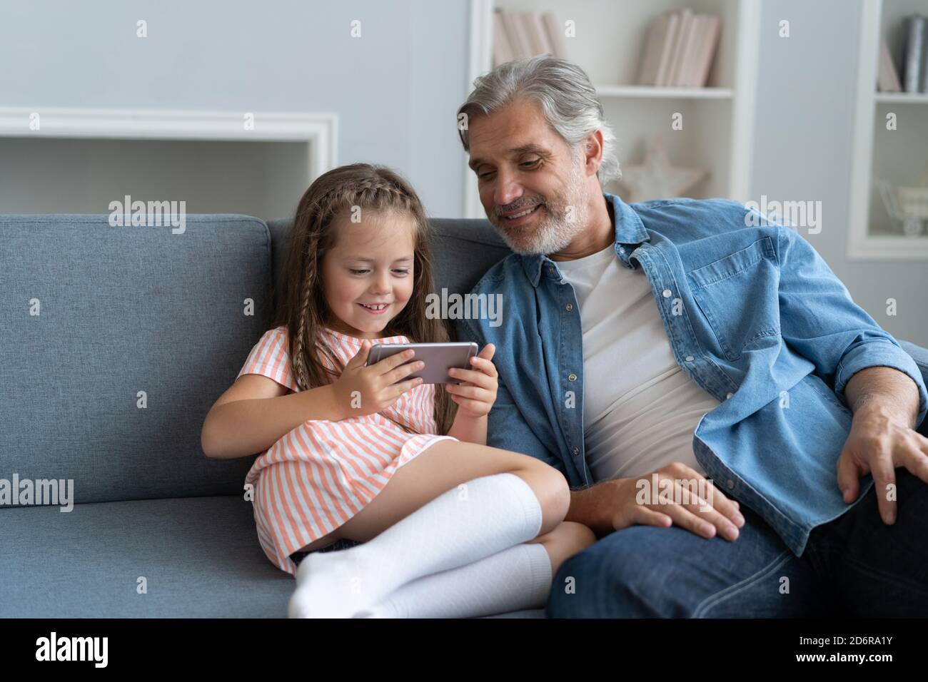 Cute girl help father show something on smartphone, smart little ...