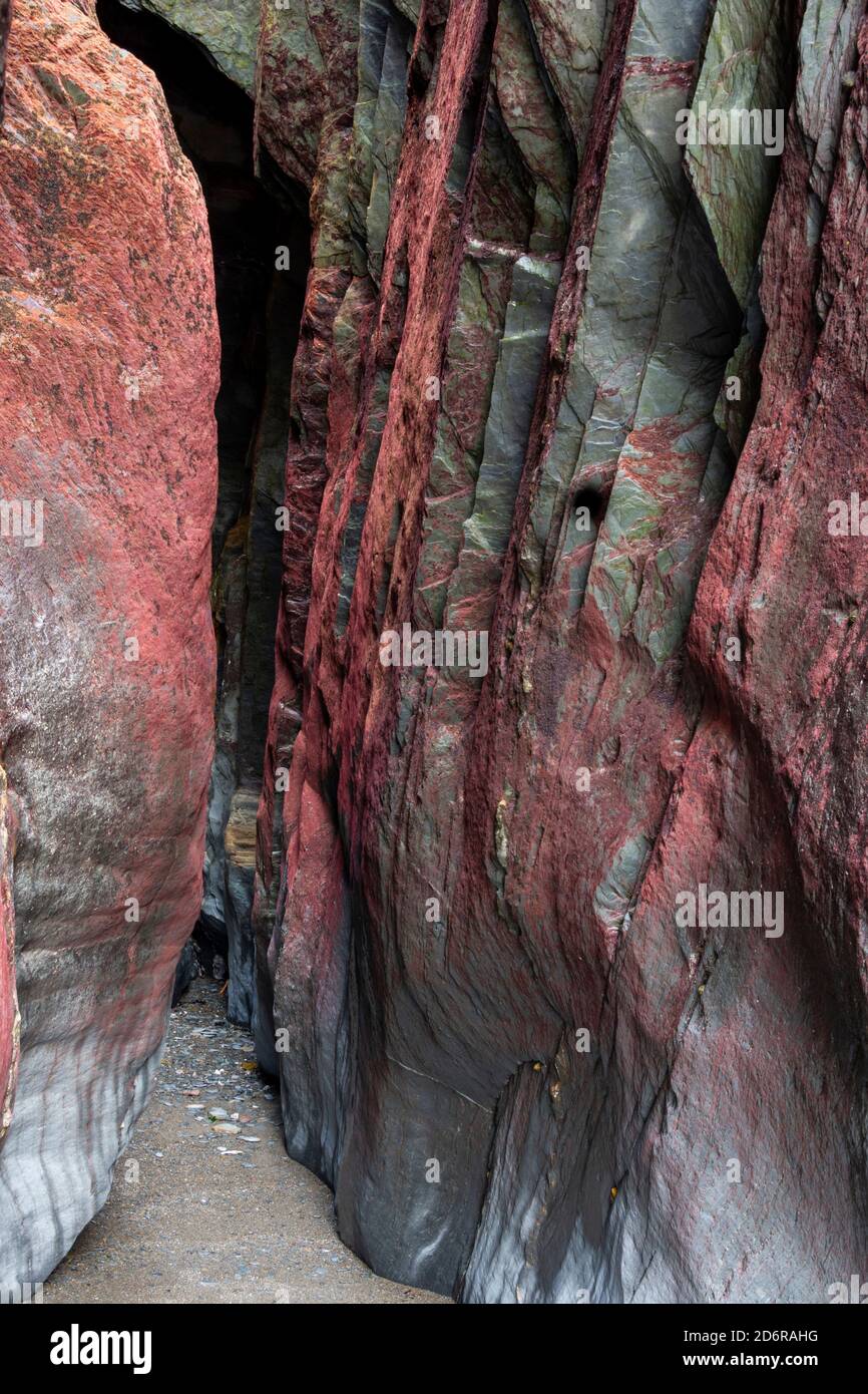 A small cave with red rocks near Combe Martin, England, UK Stock Photo ...