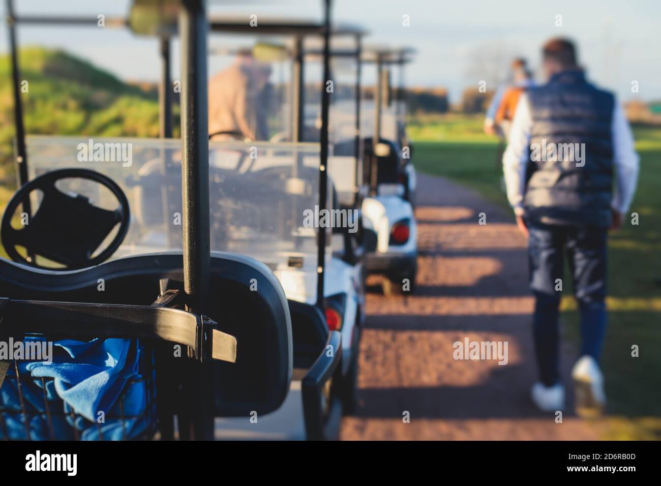 Golf electric cars riding on a golf course in the day, golf carts drive ...