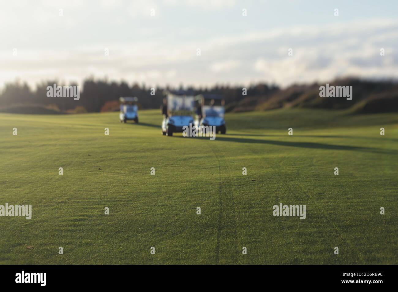 Golf electric cars riding on a golf course in the day, golf carts drive ...