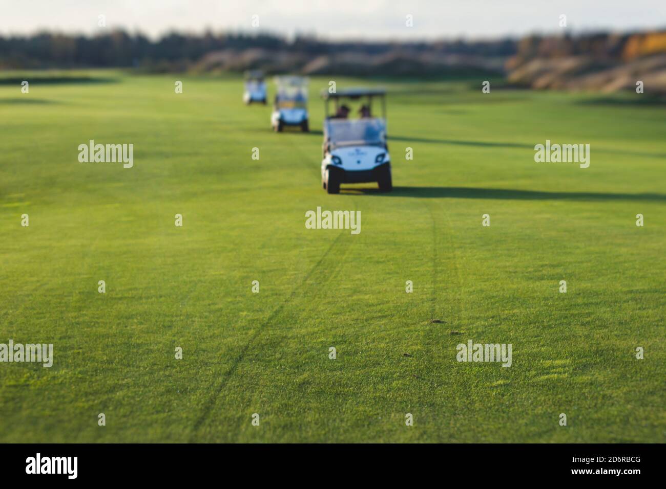 Golf electric cars riding on a golf course in the day, golf carts drive ...