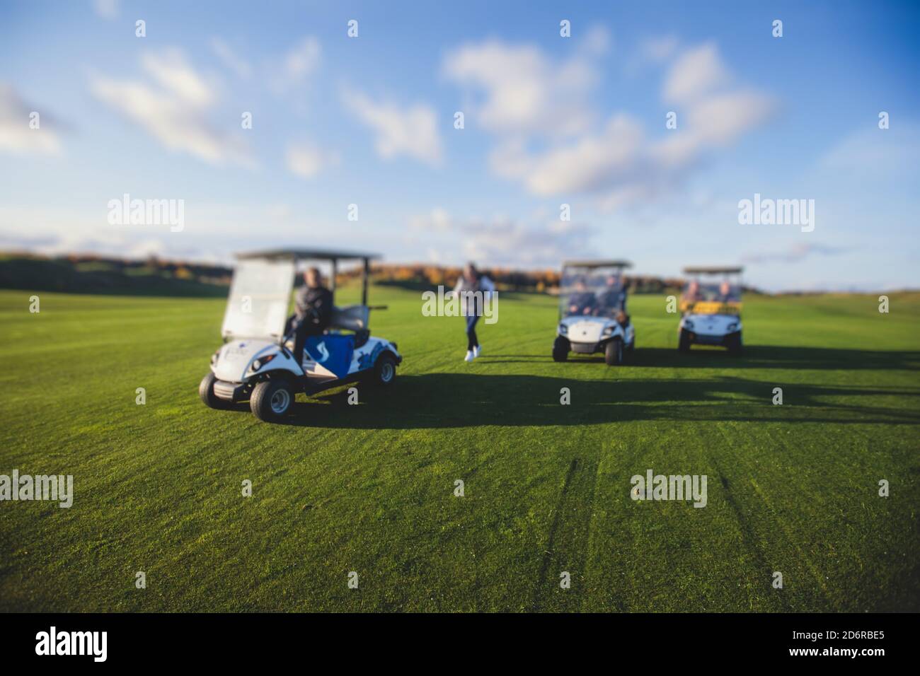 Golf electric cars riding on a golf course in the day, golf carts drive ...