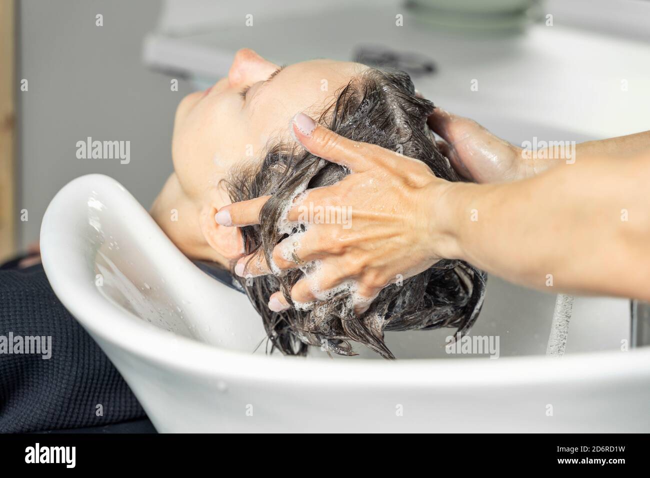 young woman enjoys shampooing in beauty salon Stock Photo - Alamy