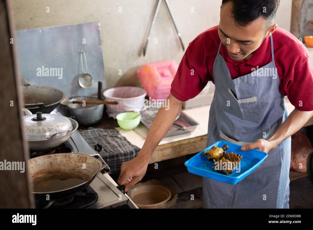the cook lights the stove to fry the side dishes for the customers at ...