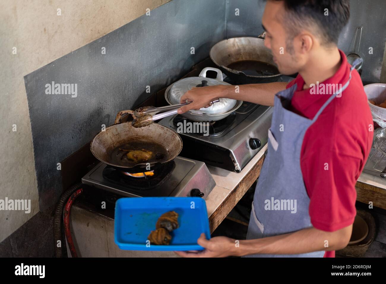 the cook lights the stove to fry the side dishes for the customers at ...