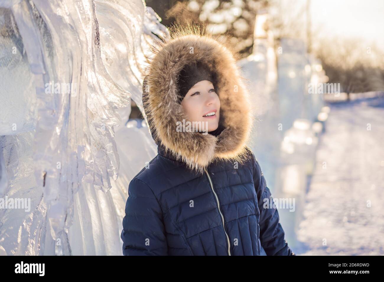 beautiful smiling young woman among the ice in wintertime outdoor ...