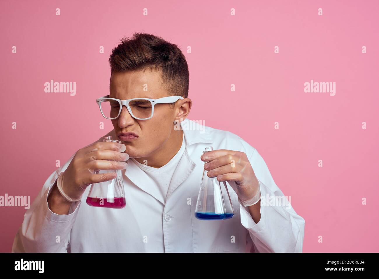 Male laboratory assistant with flasks in the hands of a multicolored ...
