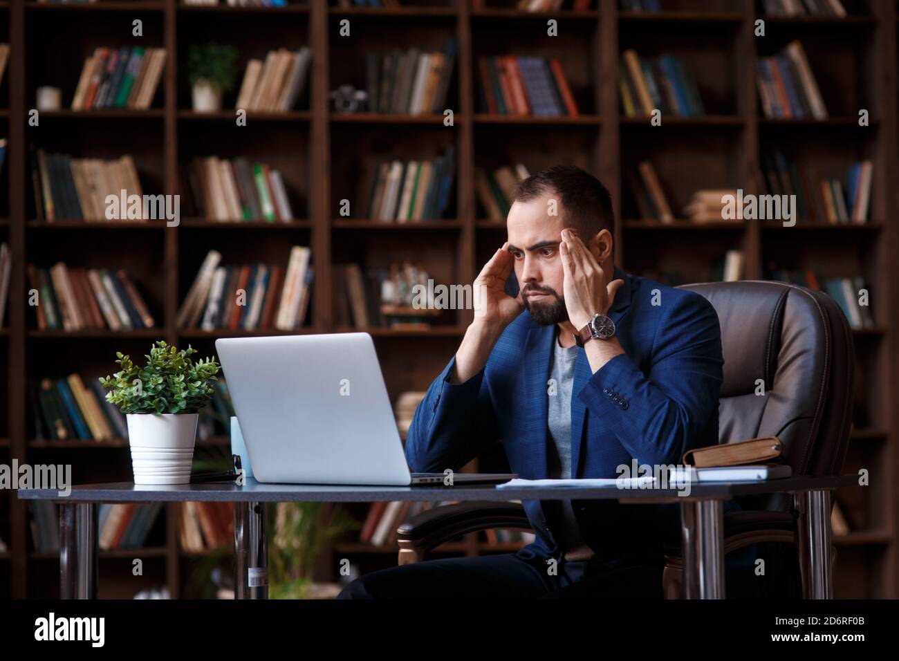 A tired young man feels pain from overexertion of the eyes, rubbing dry ...