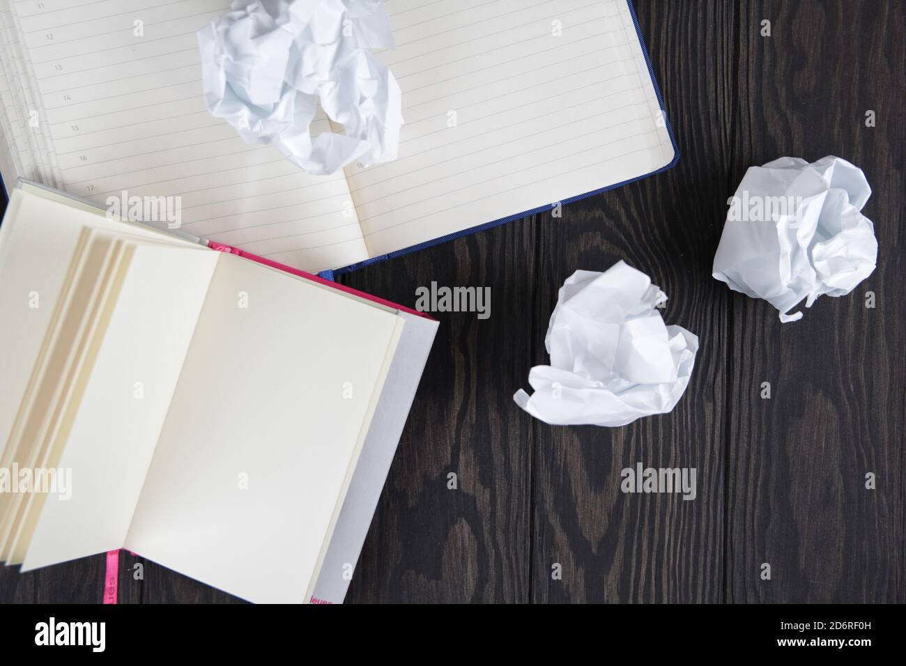 Writing concept - crumpled up paper wads with a sheet of white paper ...