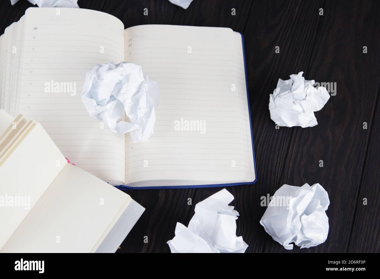 Writing concept - crumpled up paper wads with a sheet of white paper ...