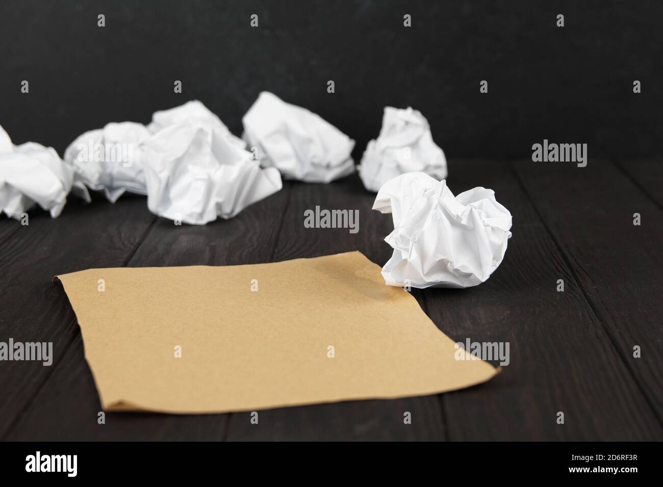 Writing concept - crumpled up paper wads with a sheet of white paper ...