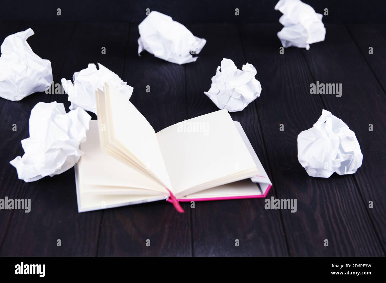Writing concept - crumpled up paper wads with a sheet of white paper ...