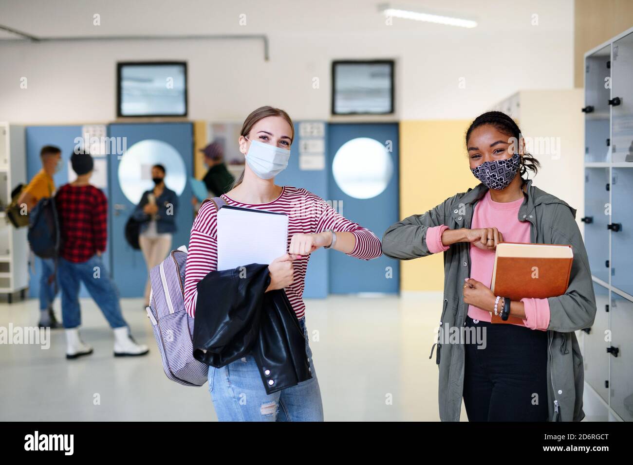 Young students friends with face masks back at college or university ...