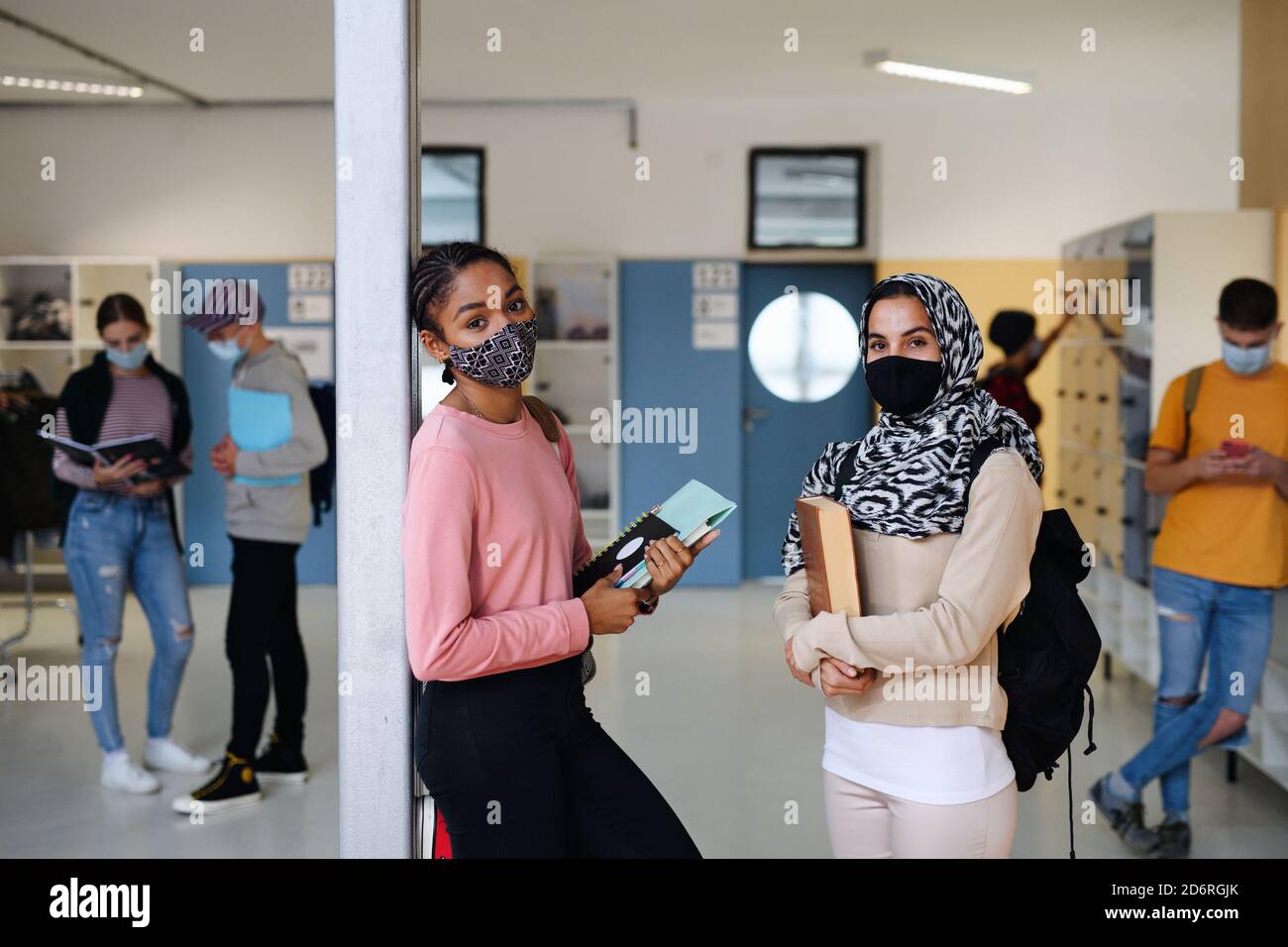 Young students friends with face masks back at college or university ...