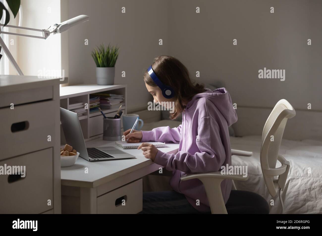 Girl doing homework with headset on hi-res stock photography and images ...