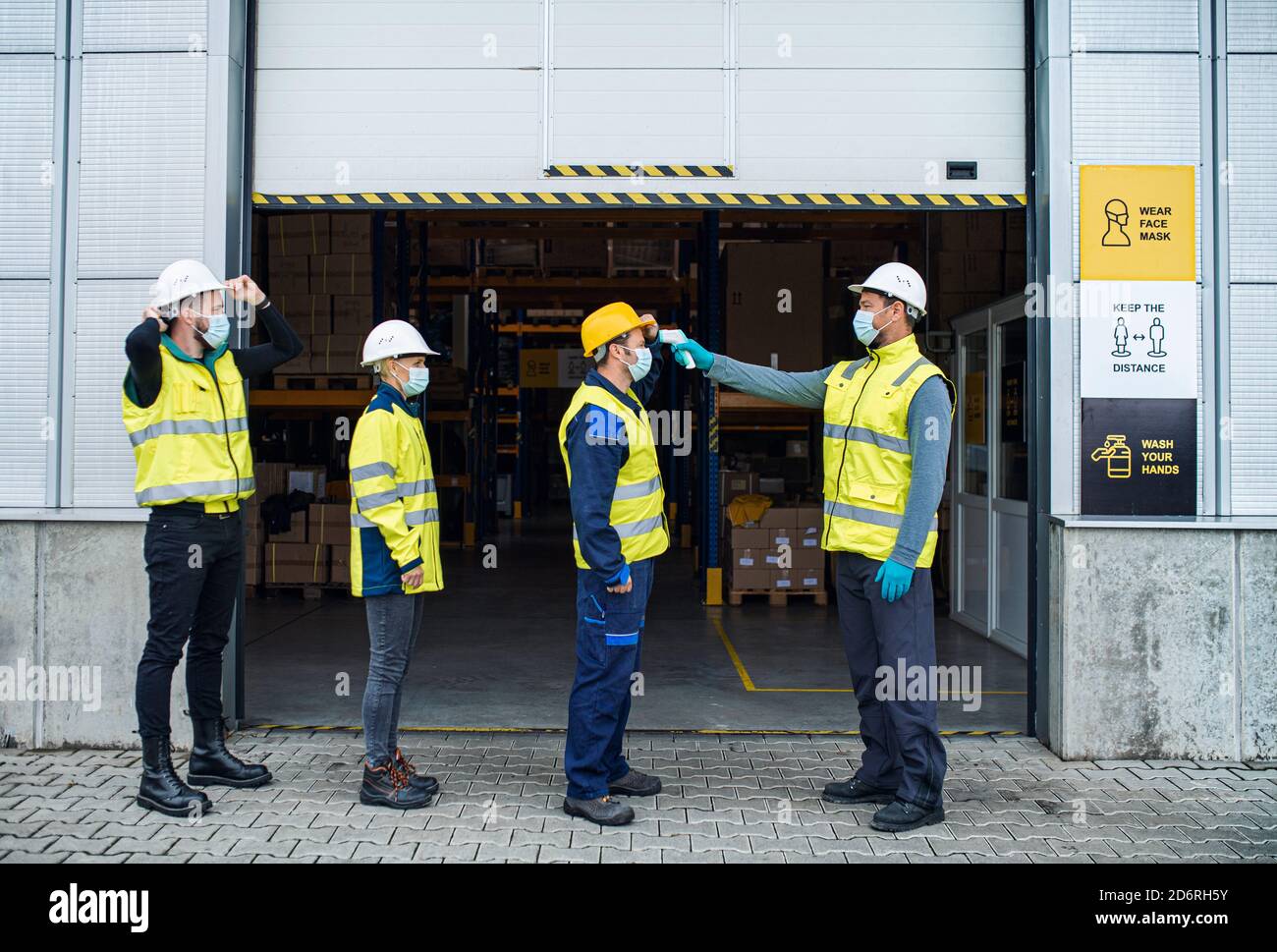 Group of workers with face mask in front of warehouse, coronavirus and ...