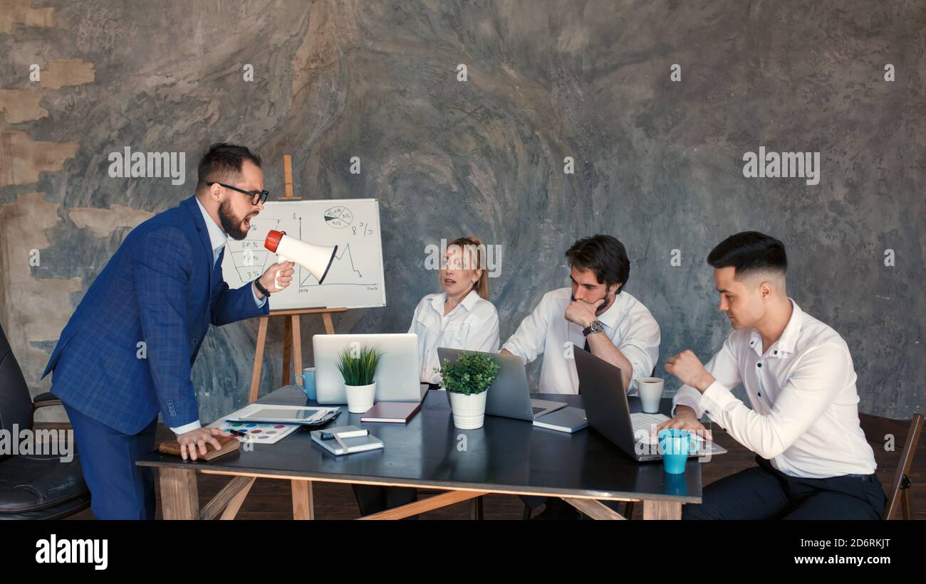 Angry boss reprimanding employee for bad work result sitting at ...