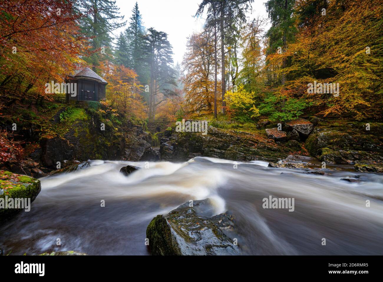 Autumn view of Ossian’s Hall overlooking cascade of Black Linn Falls on ...