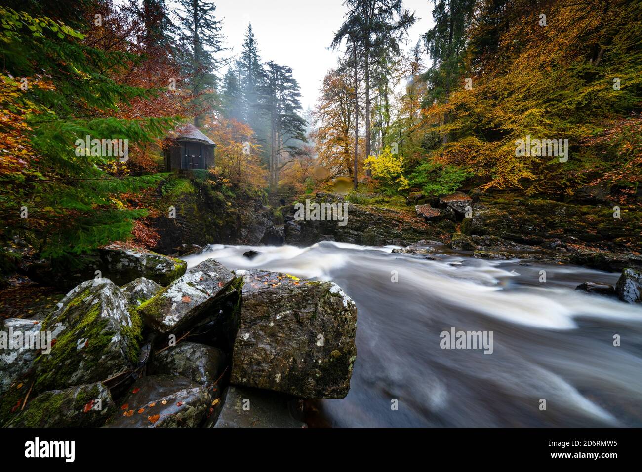 Autumn view of Ossian’s Hall overlooking cascade of Black Linn Falls on ...
