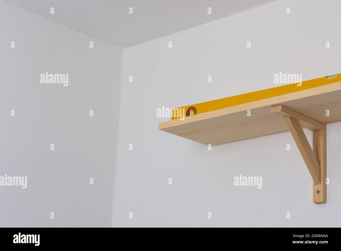 The process of fixing the wooden shelf to the wall, the level tool ...