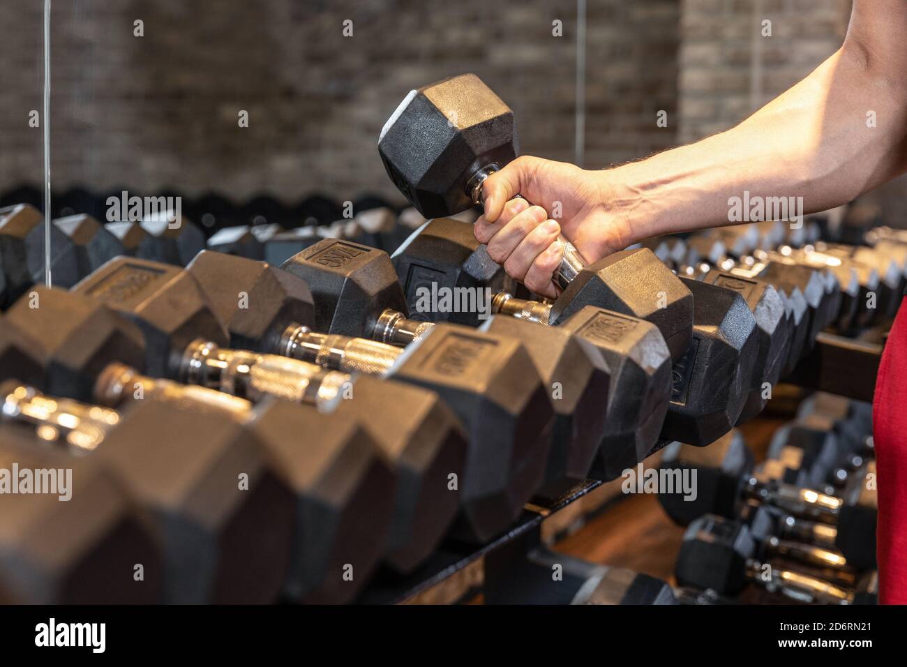 Unrecognizable man taking a dumbbell in a gym close up Stock Photo - Alamy