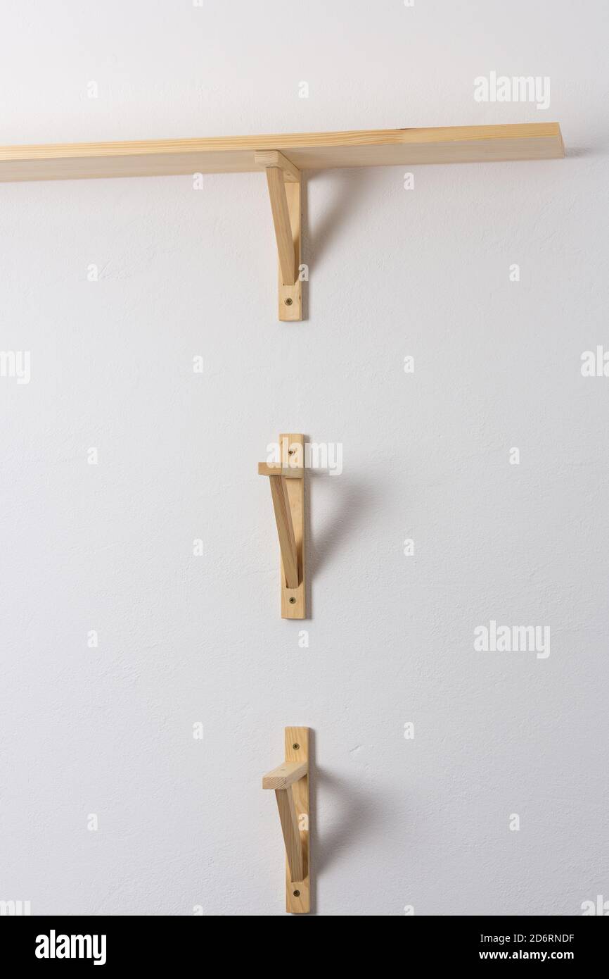 The process of attaching a wooden shelf to the wall, shelf corners ...