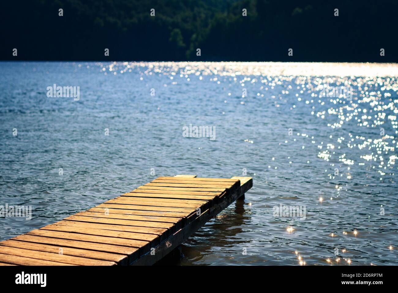Wooden pier on lake, blur background Stock Photo - Alamy
