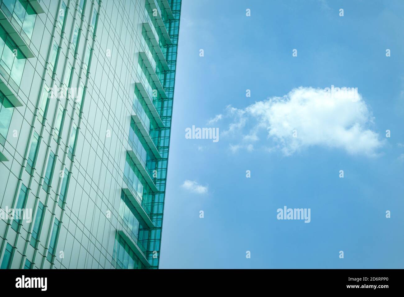 Modern high rise building against blue sky with a spot of white fluffy ...