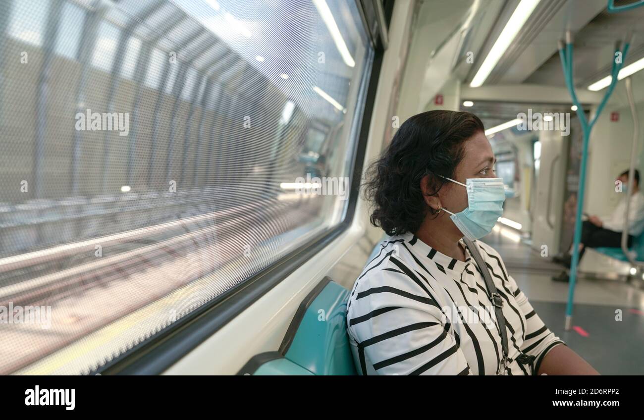Woman commuter wearing face mask inside subway train. Travel new normal ...