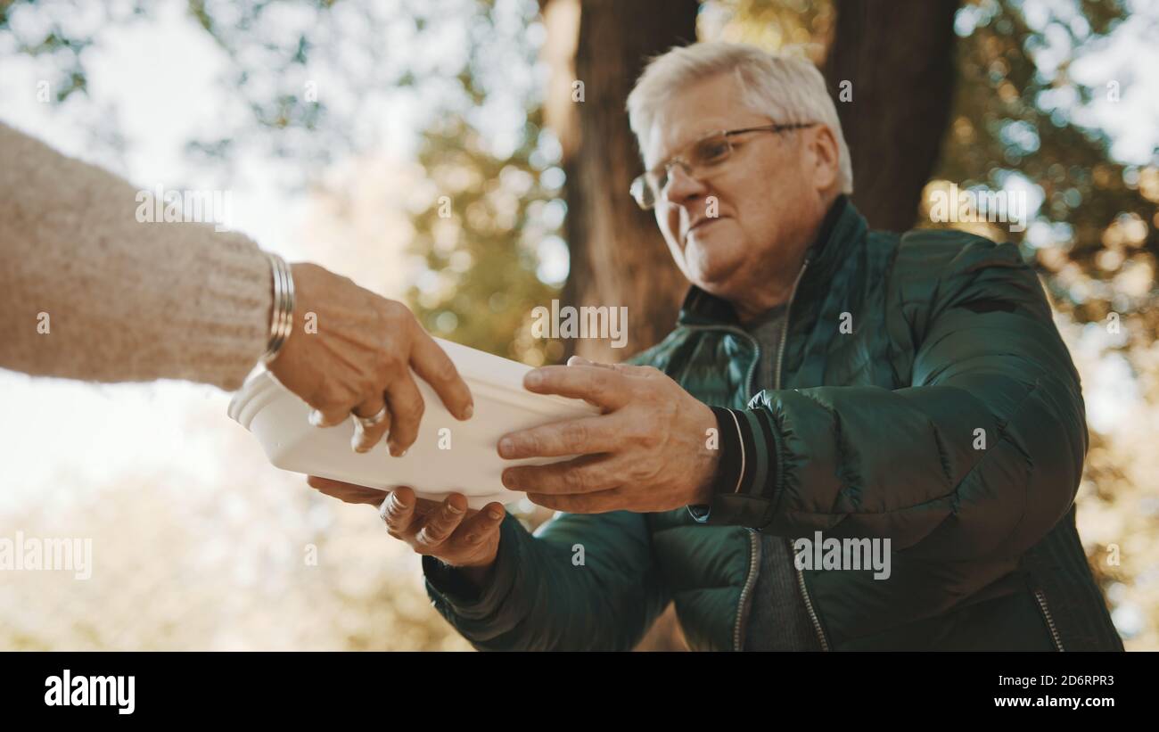 Old vulnerable homeless man getting free charity meal. High quality ...