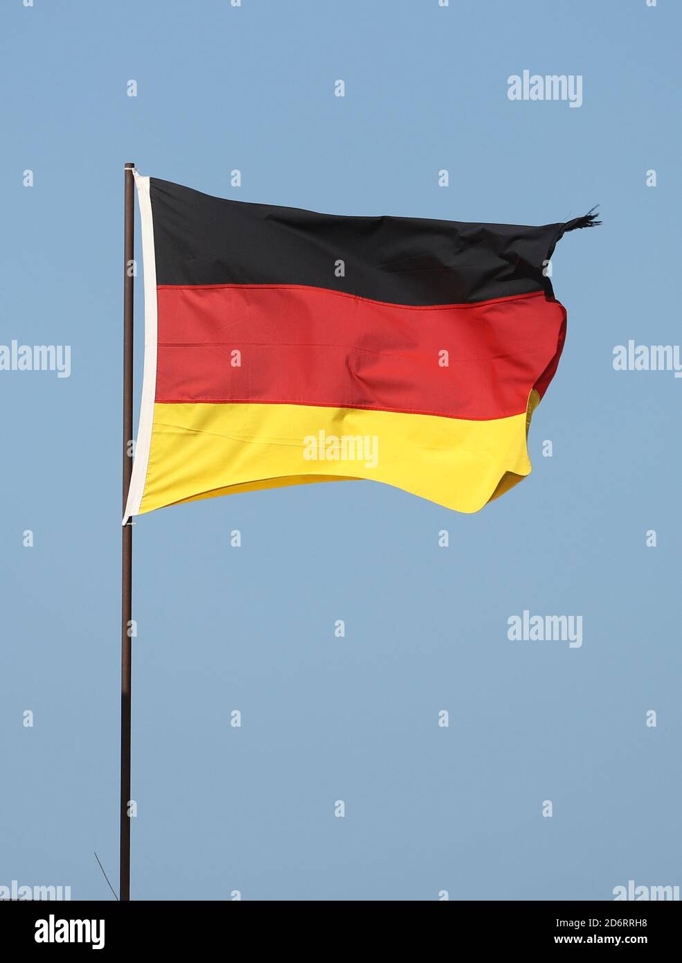 German flag flying on flagpole on blue sky background Stock Photo - Alamy