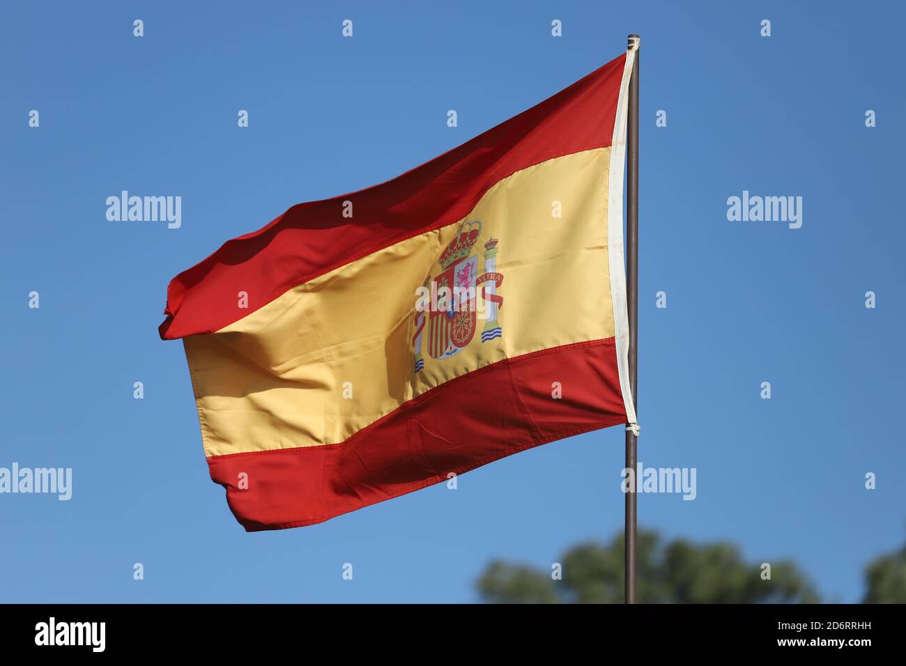 Spanish flag flying on flagpole on blue sky background Stock Photo - Alamy