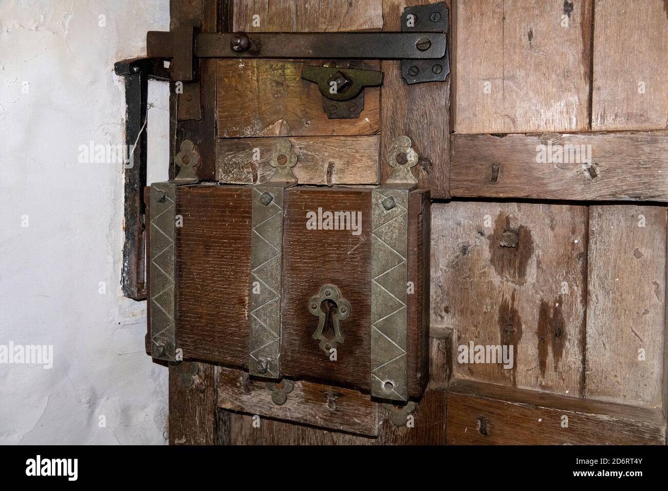 Antique wood and metal large church door lock on wood panelled door ...