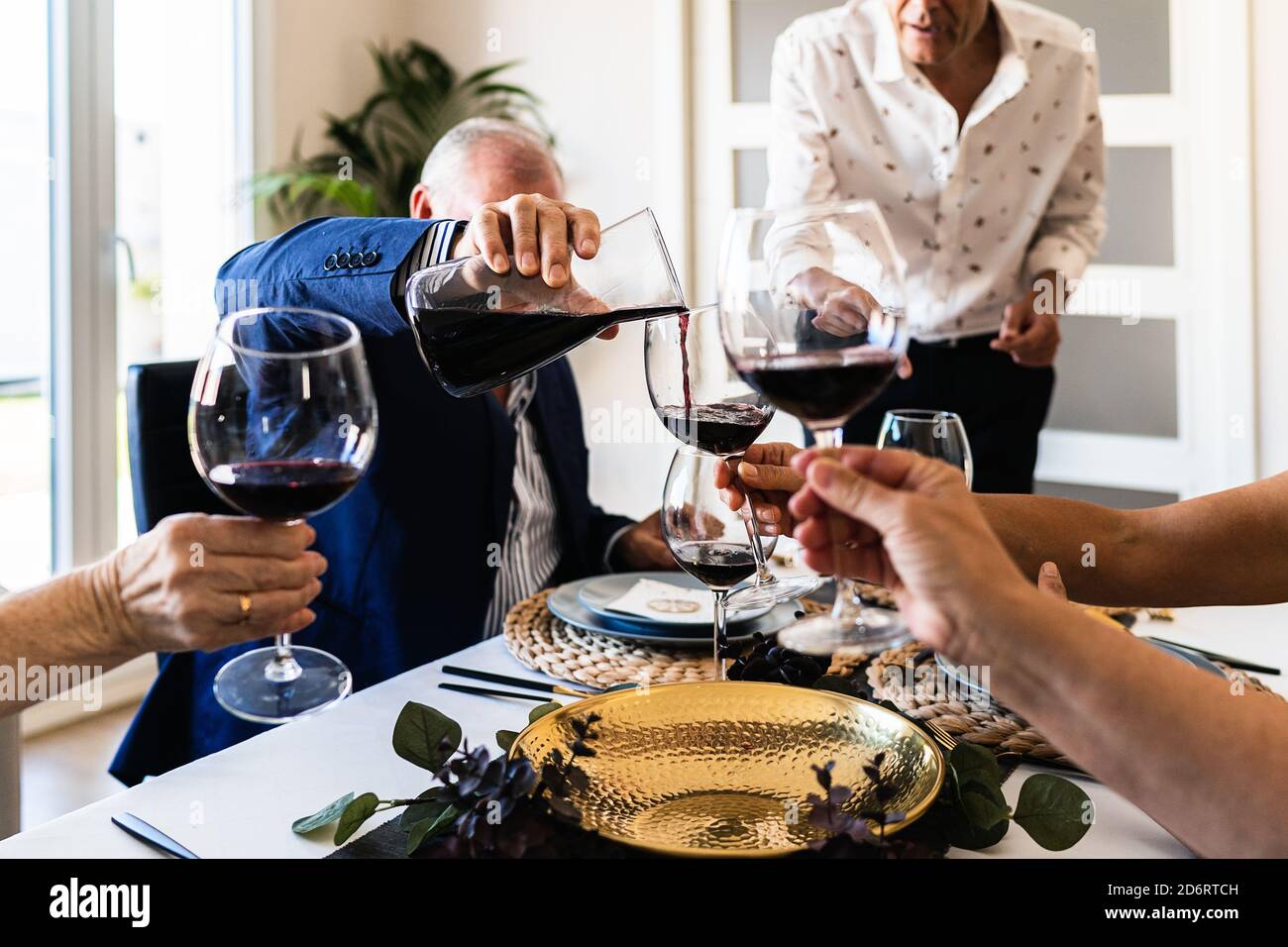 Anonymous old man serving red wine during Christmas dinner Stock Photo ...