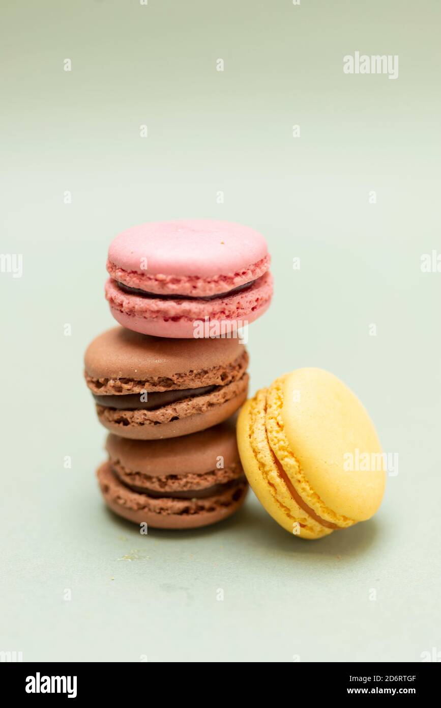Pile of colored tasty macaroons over a green background Stock Photo - Alamy