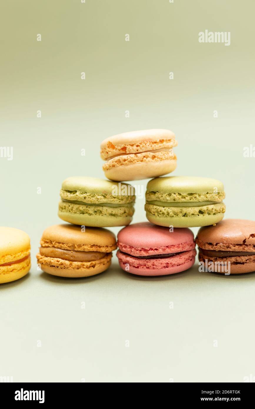 Pile of colored tasty macaroons over a green background Stock Photo - Alamy